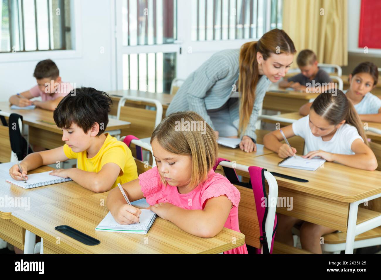Teacher giving advices to kids during lesson Stock Photo - Alamy