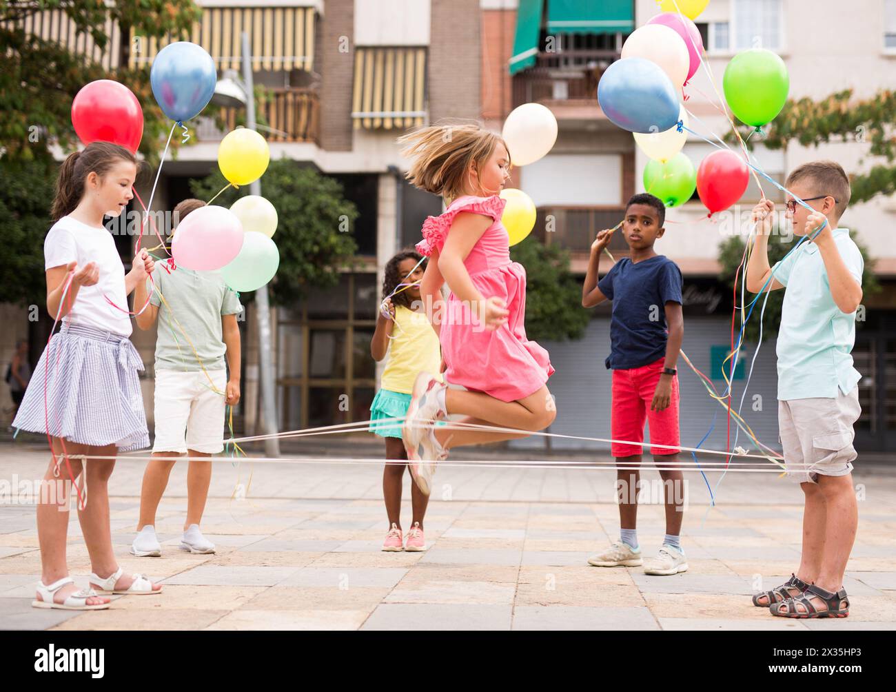 Kids playing with Chinese jumping rope outdoors Stock Photo - Alamy