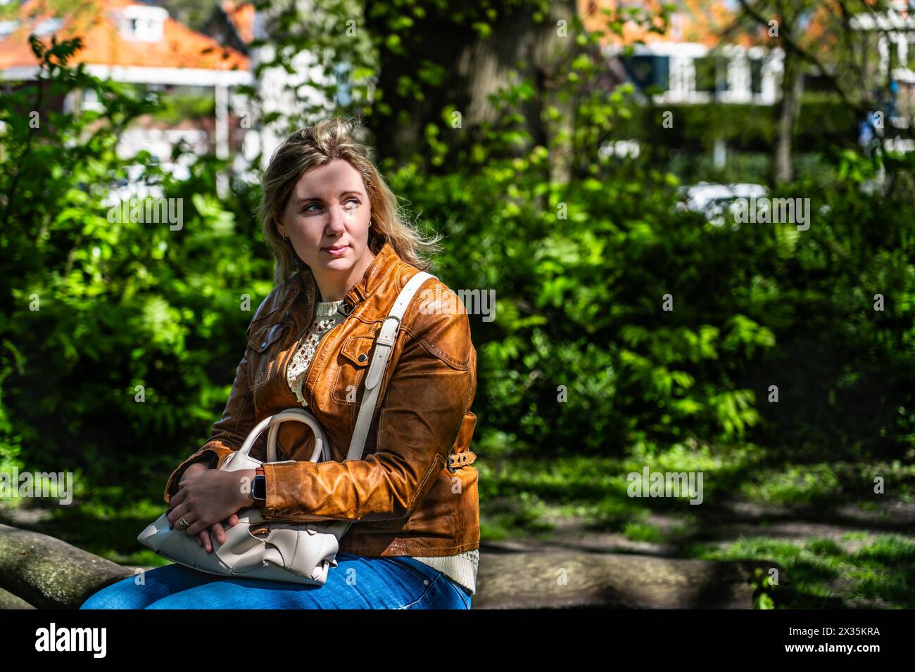Stylish atractive blonde woman sitting and looking over her shoulder on ...