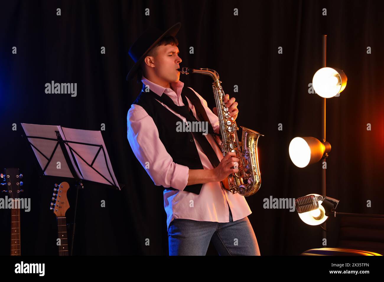 Handsome man playing saxophone on stage Stock Photo - Alamy