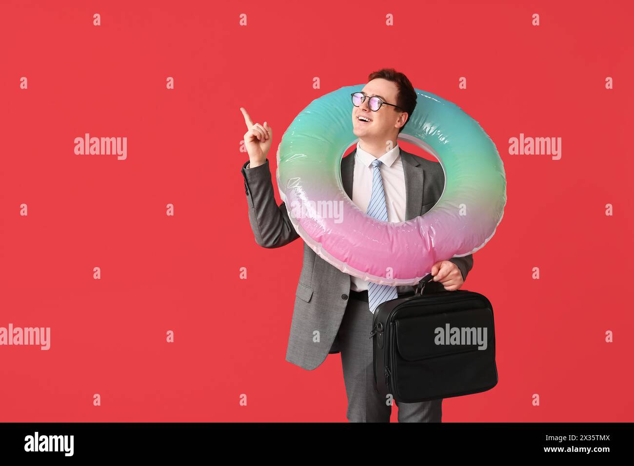 Office worker with raised index finger and inflatable ring dreaming ...