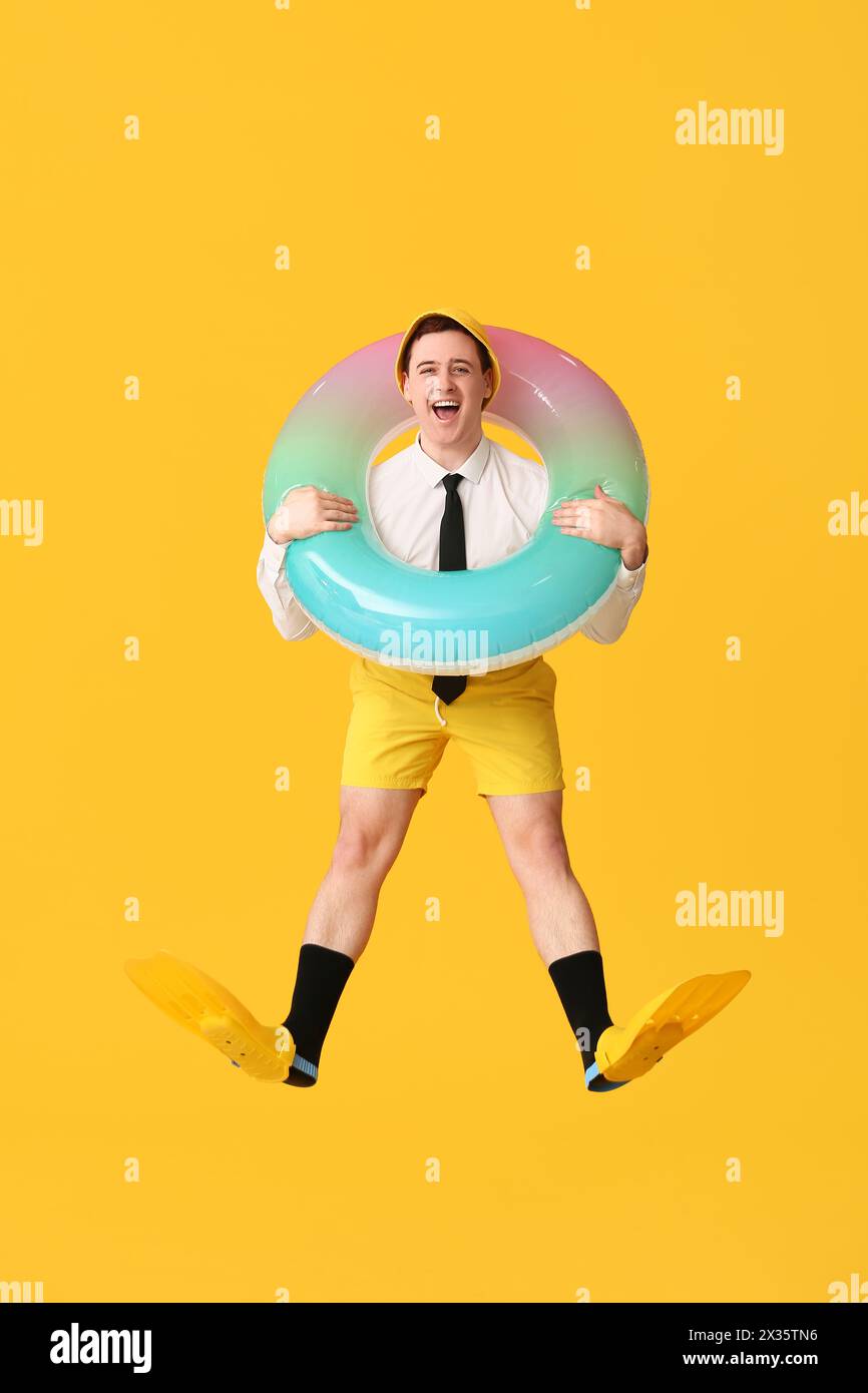 Office worker with inflatable ring and flippers dreaming about vacation ...