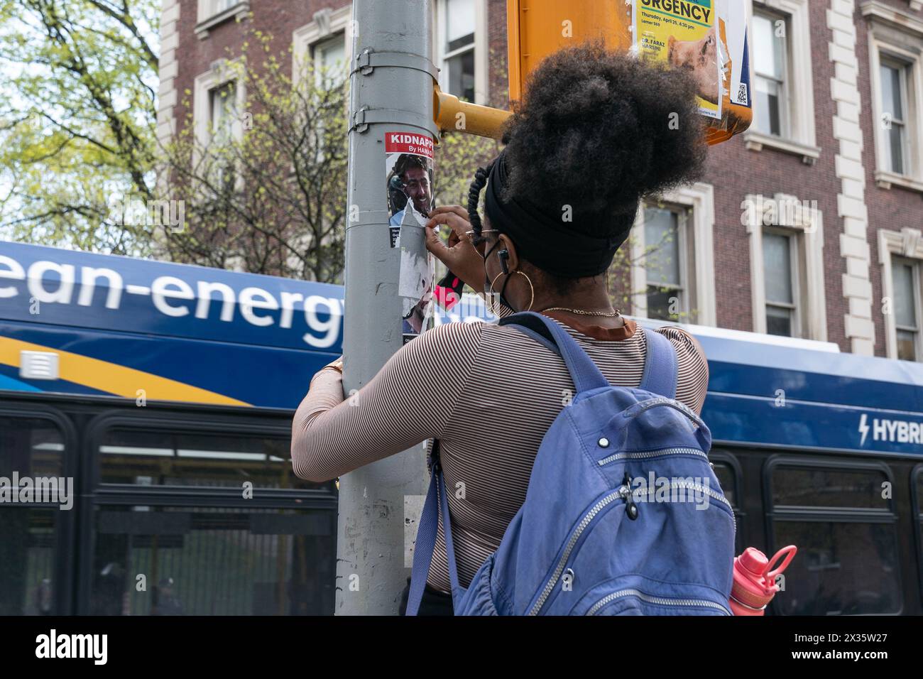 New York, USA. 24th Apr, 2024. Activist rippes off poster of kidnapped ...