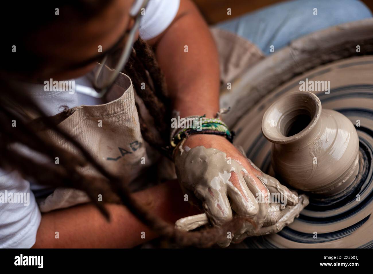Hands of a male potter making a clay container on the potter's wheel ...