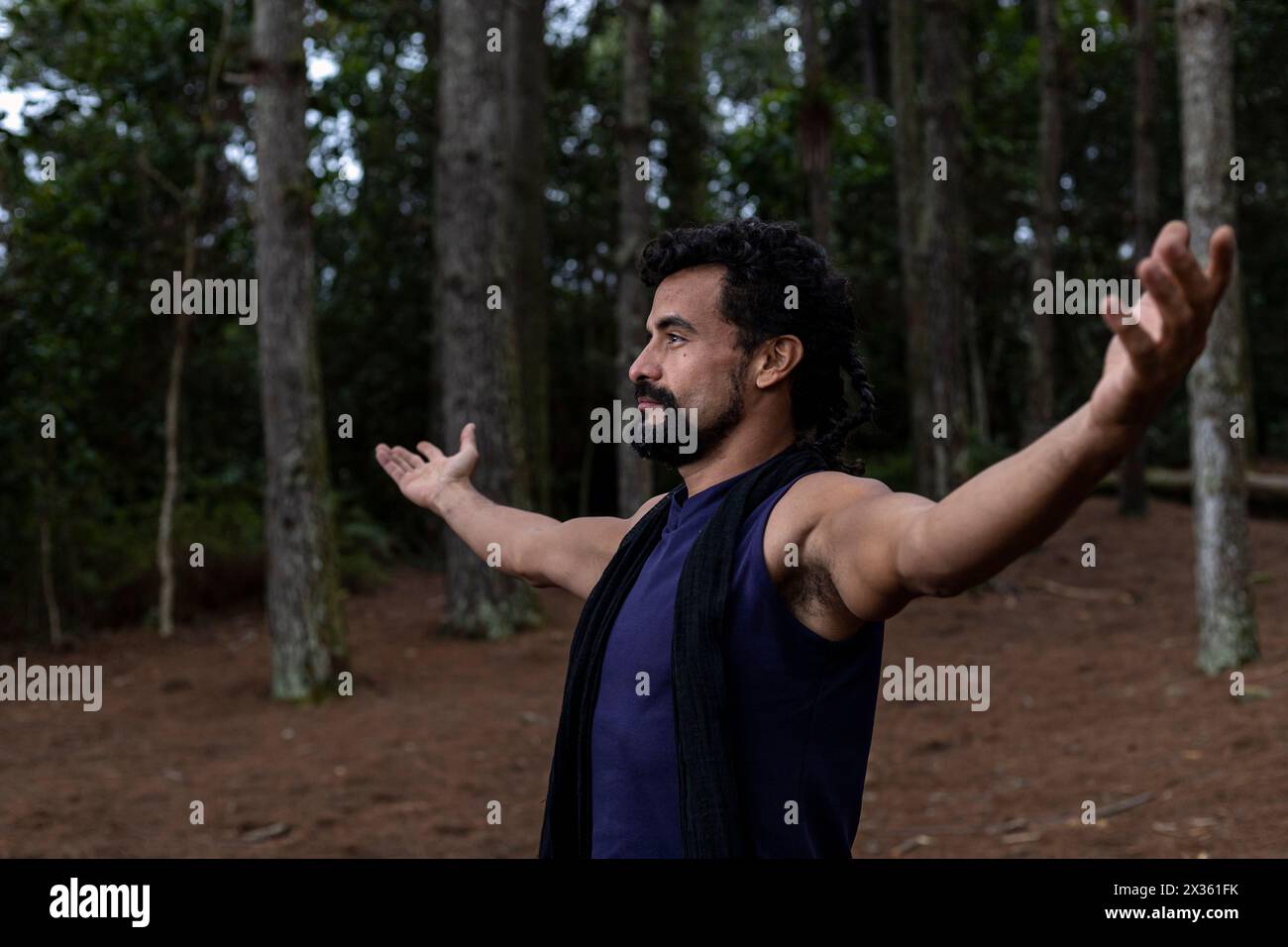 Latin American young woman (37) inside a pine forest with her arms open ...