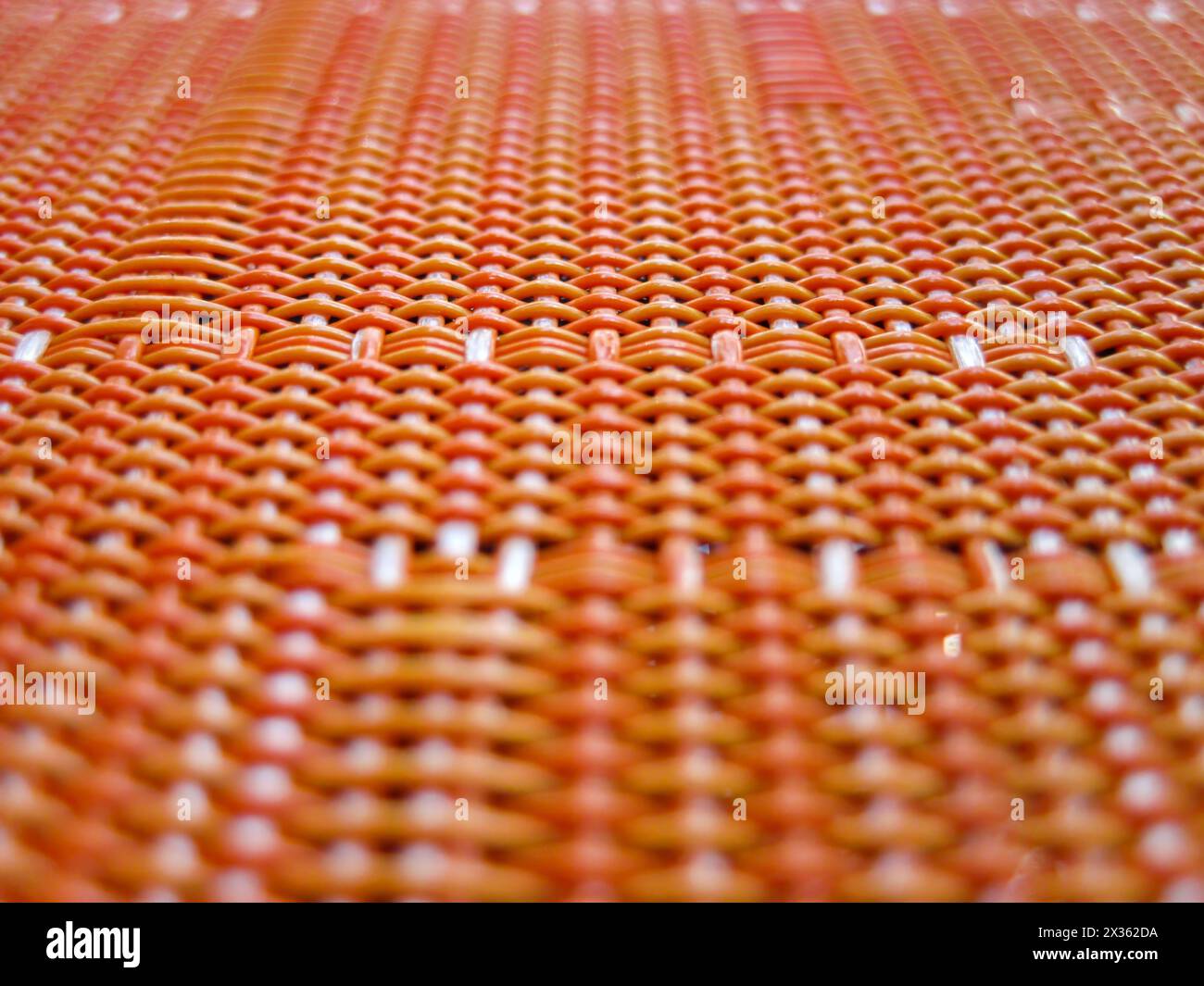 The orange and white woven fabric has a pattern of triangles. The ...