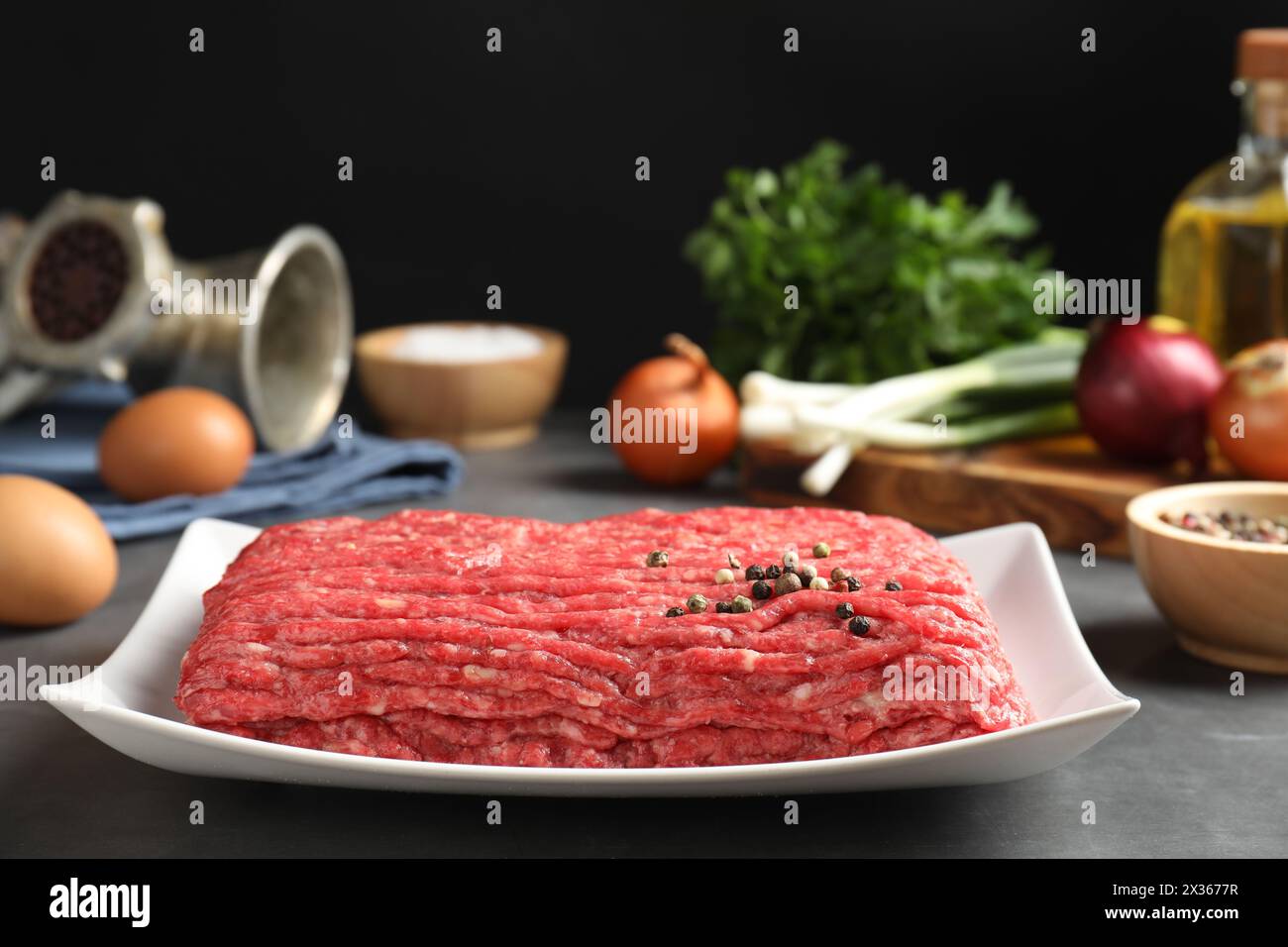 Raw ground meat and different products on grey table Stock Photo - Alamy