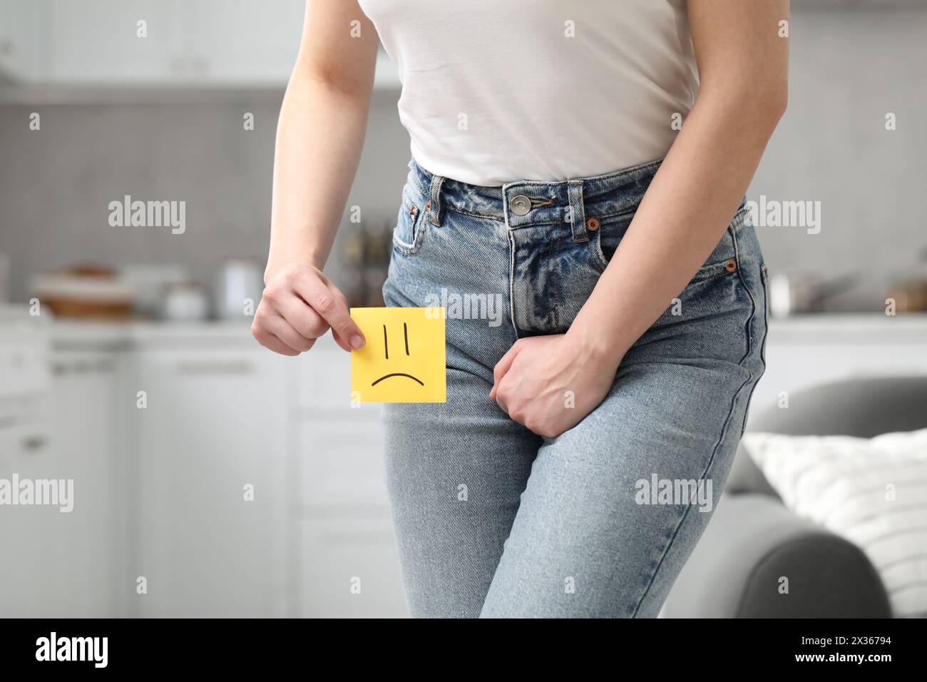 Woman holding sticky note with drawn sad face and suffering from ...