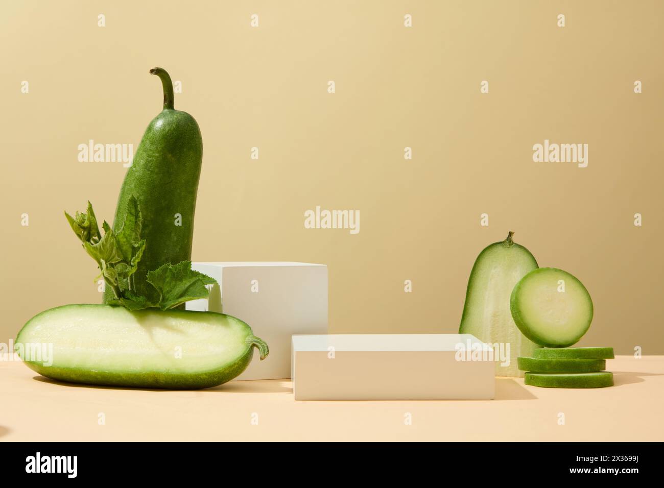 Winter melon cut in half and slices arranged with white pedestals ...