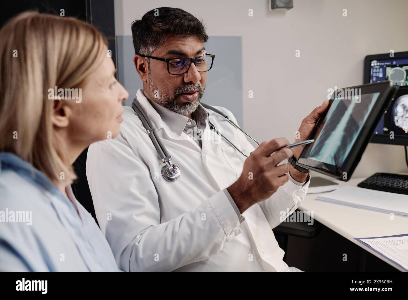 Biracial professional radiographer showing chest X-ray image on digital ...