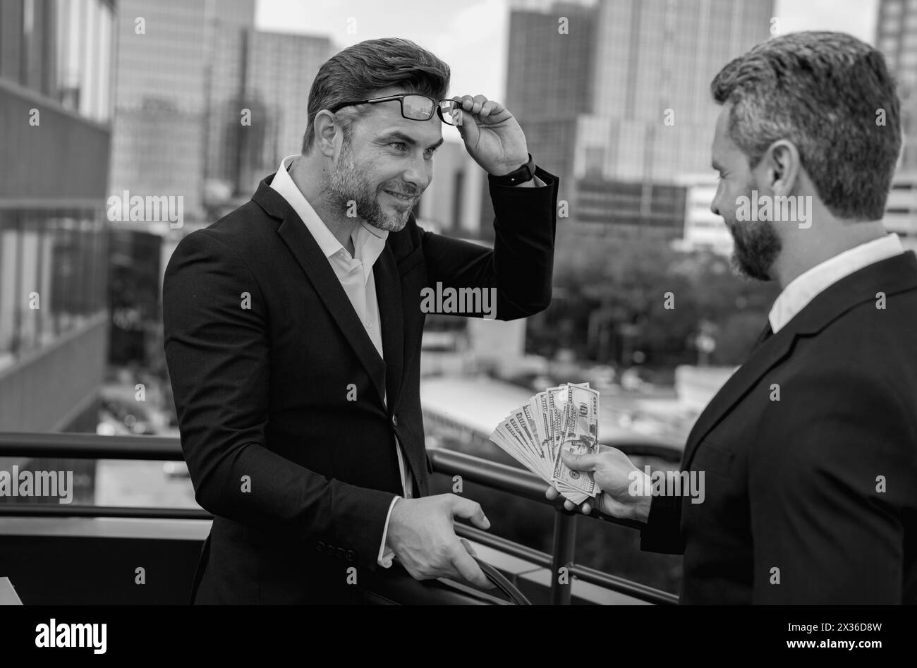 Businessman giving money to his partner outdoor. Businessman giving ...