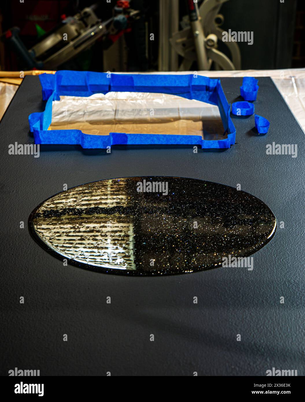 Applying blue painters to build a dam to prevent epoxy from spilling ...