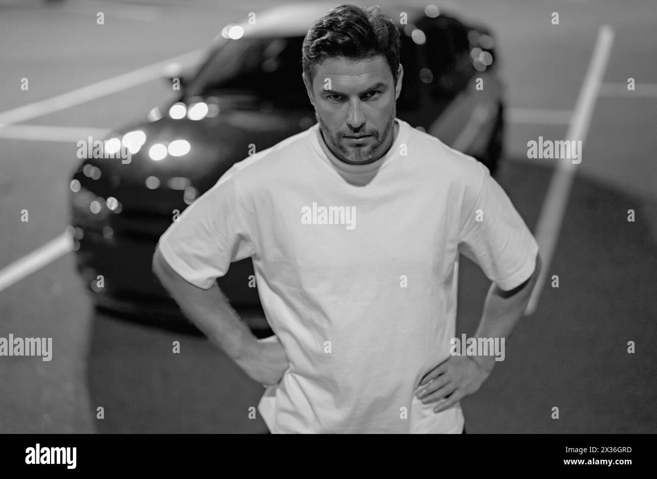 Gangster, criminal concept. Angry man near car on night urban street ...