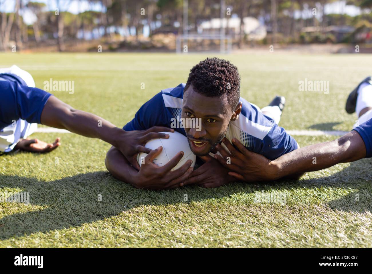 Three African American young male athletes train with rugby ball on a ...