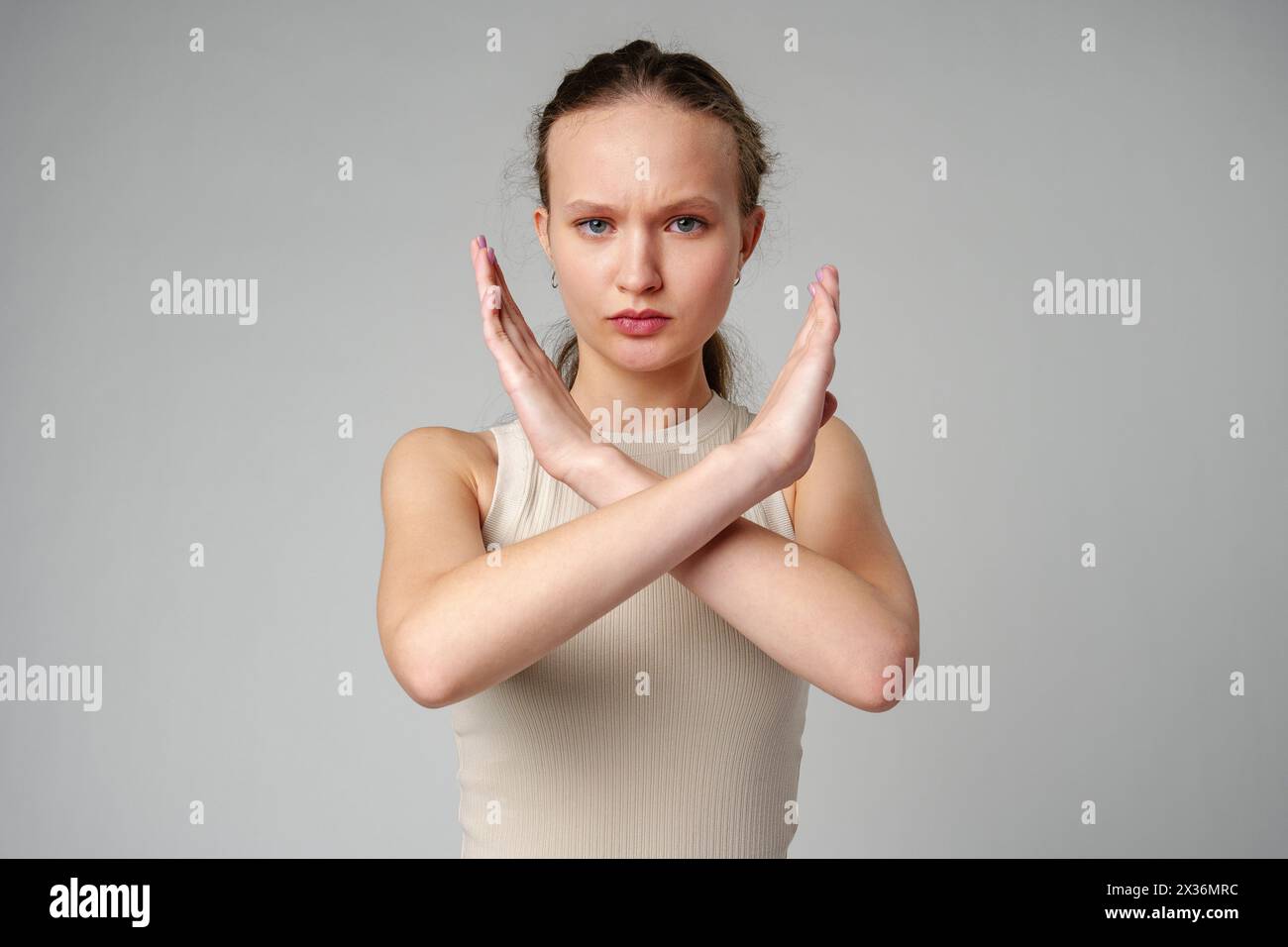 Young Woman Making Stop Sign With Hands on gray background Stock Photo ...