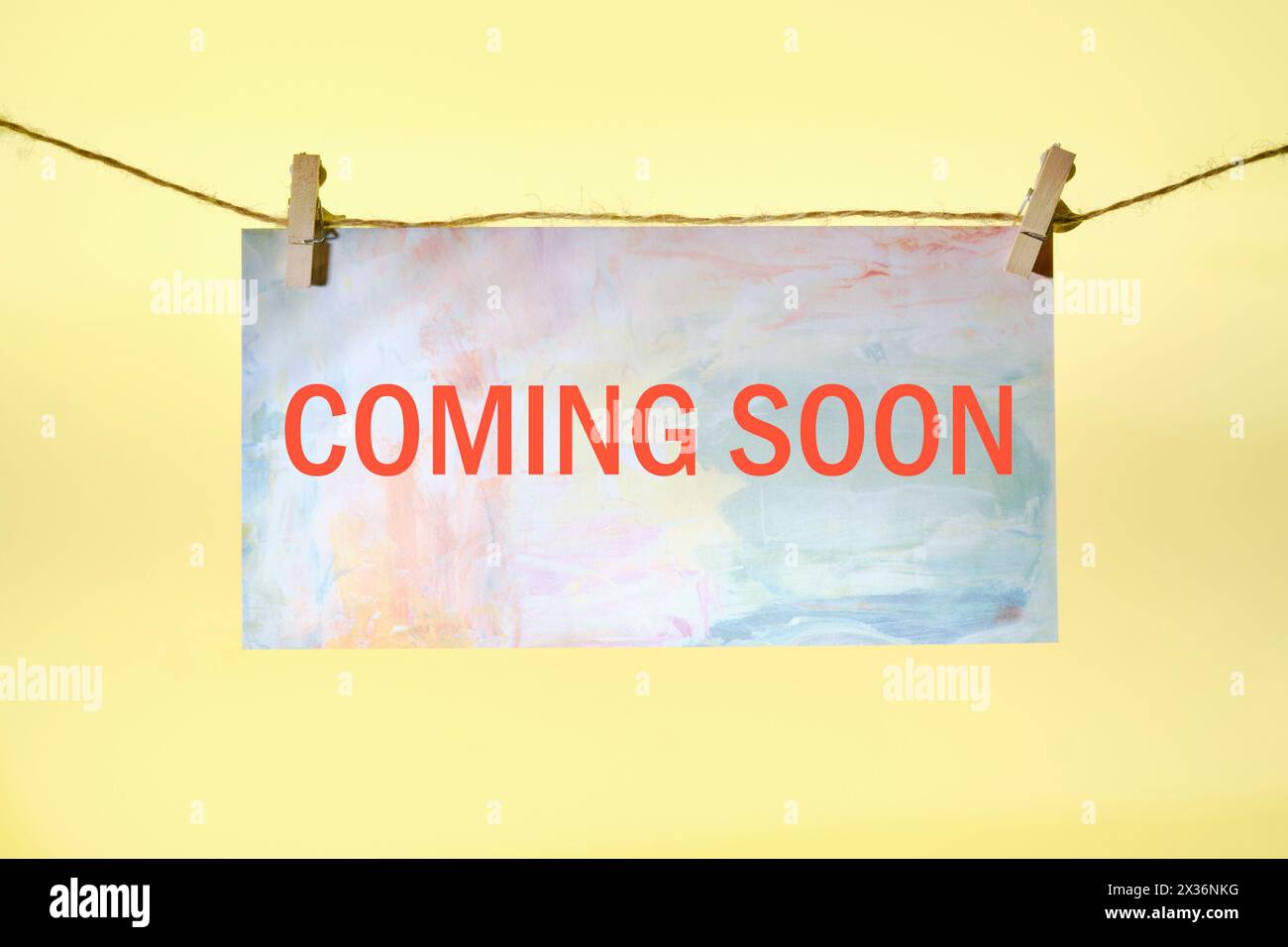 The words coming soon written on paper suspended from a rope on a ...