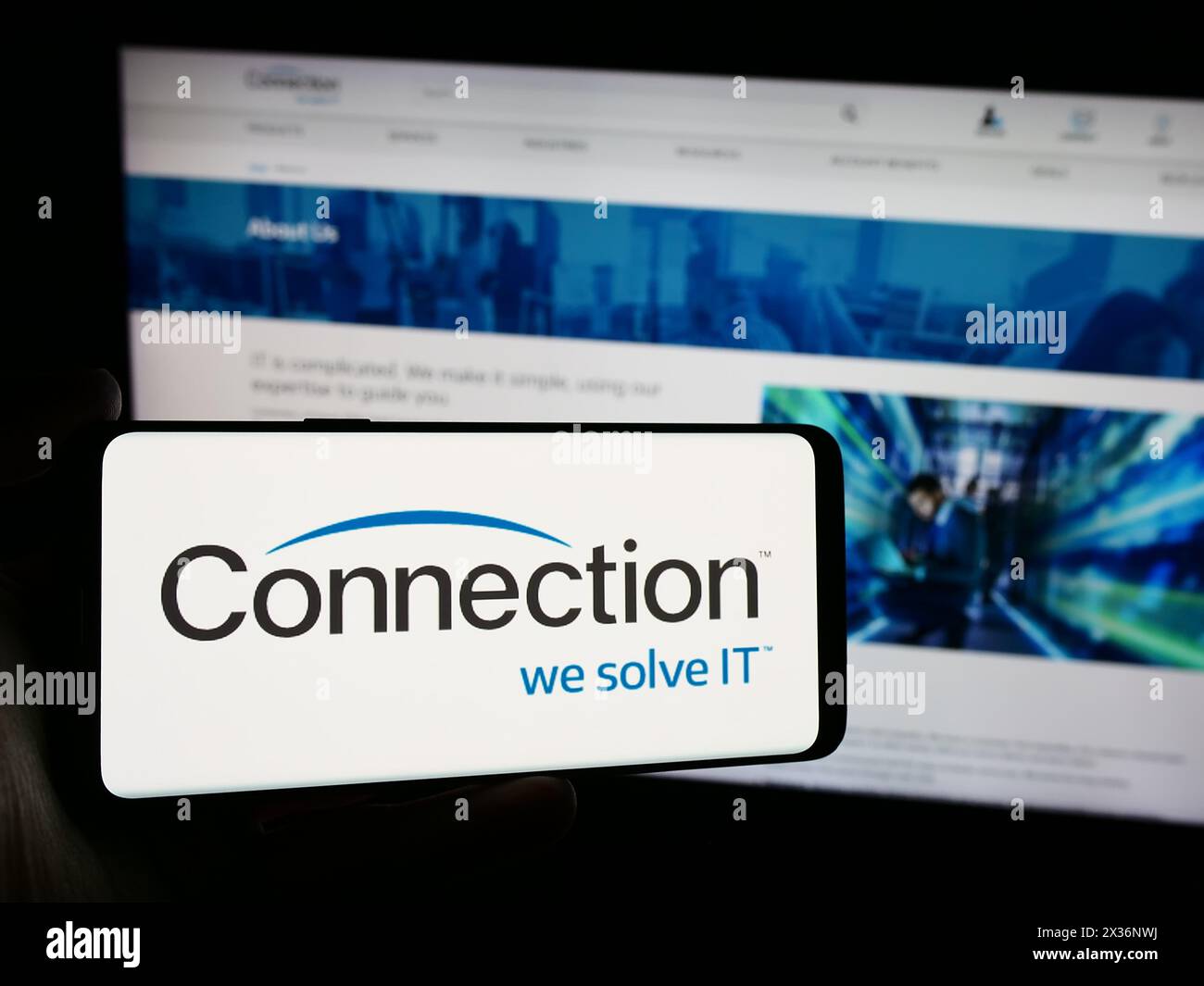 Person holding mobile phone with logo of American information ...