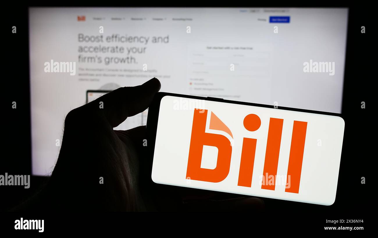 Person holding mobile phone with logo of American financial software ...