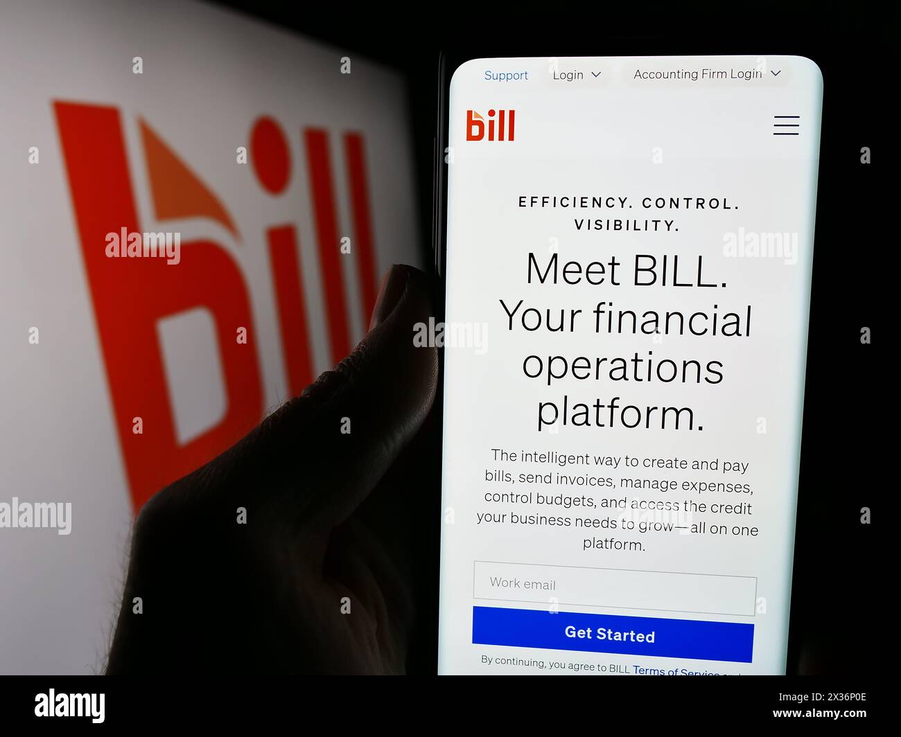 Person holding cellphone with webpage of US financial software company ...