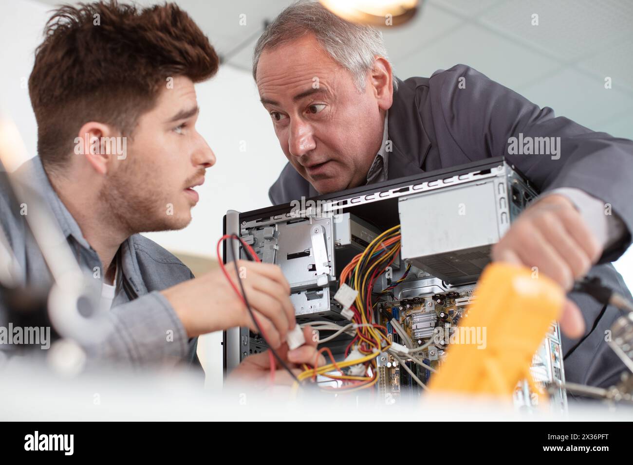 happy electronic engineers examining digital multimeter indicators ...