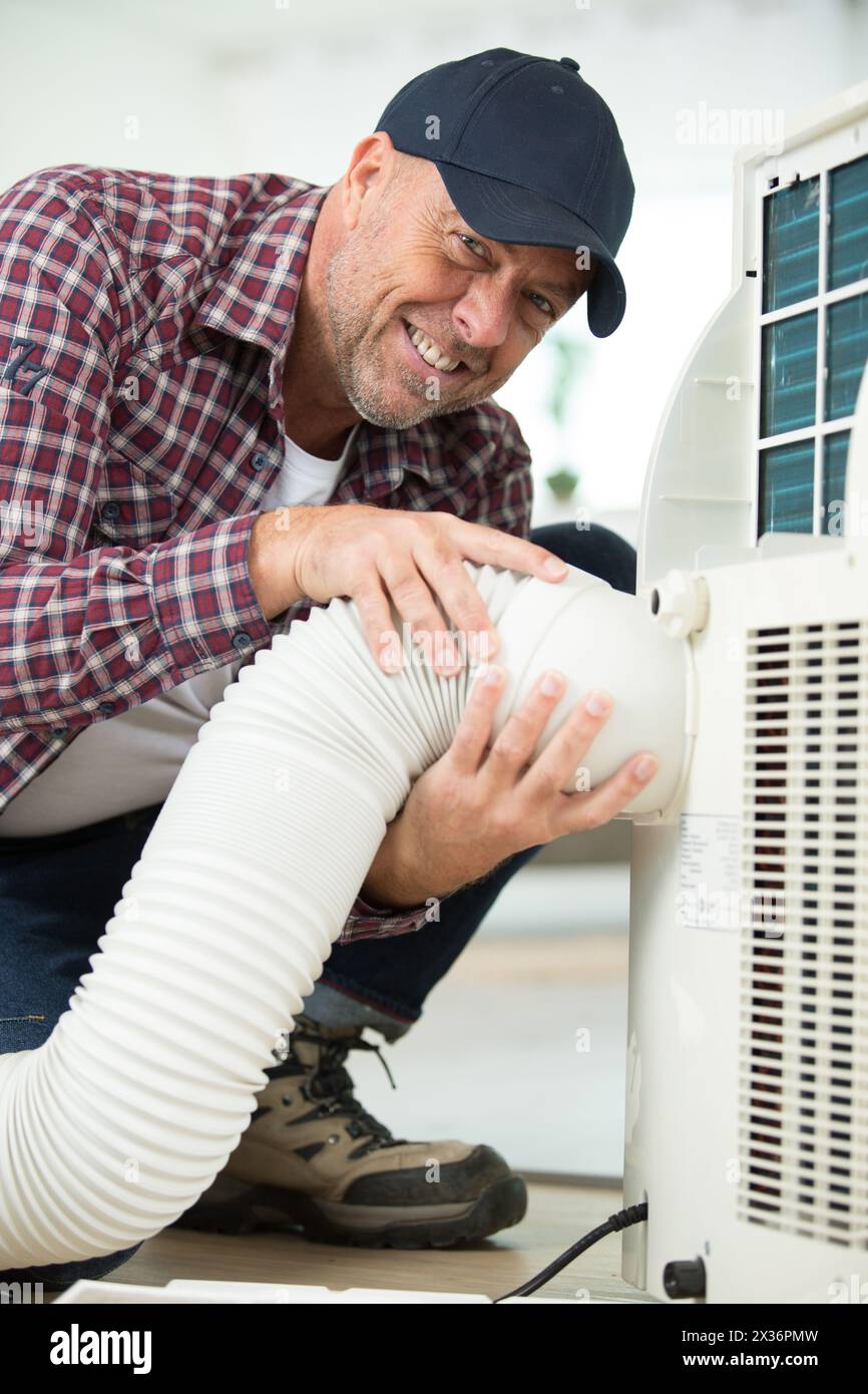 man fitting hose to ventilation system Stock Photo - Alamy