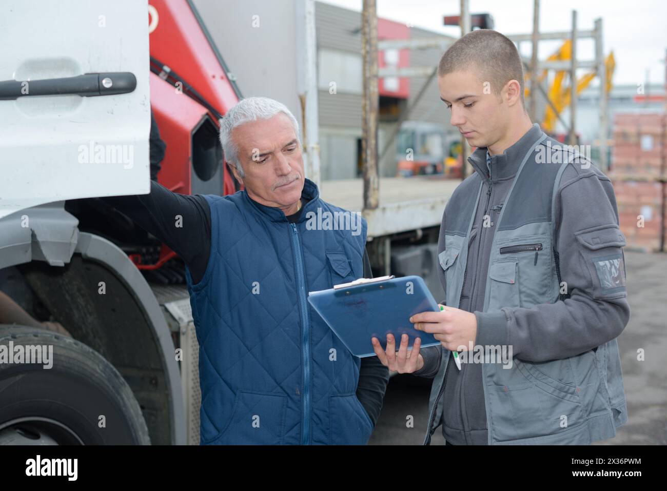 lorry driver and man holding clipboard Stock Photo - Alamy