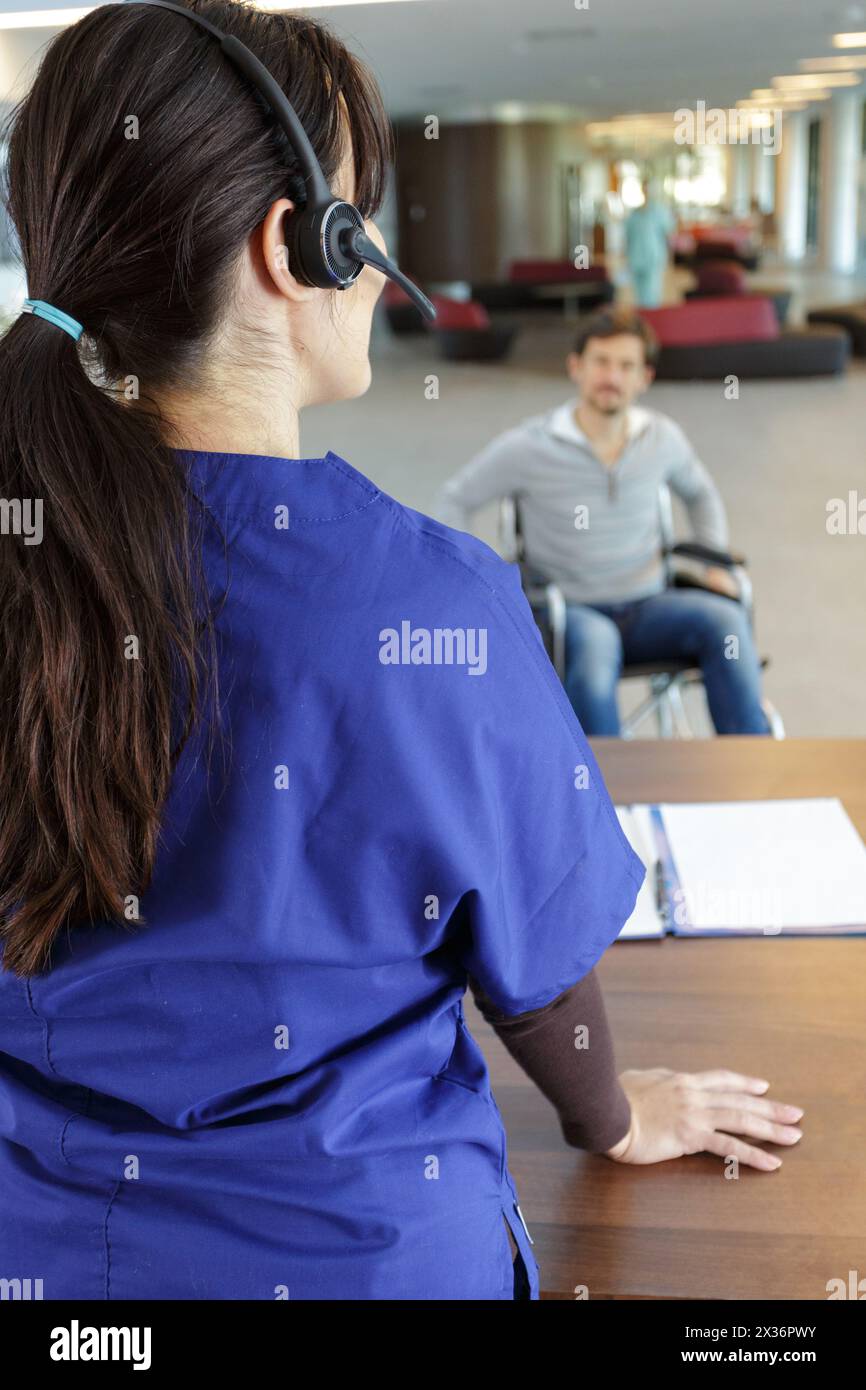hospital receptionist and approaching patient in wheelchair Stock Photo ...