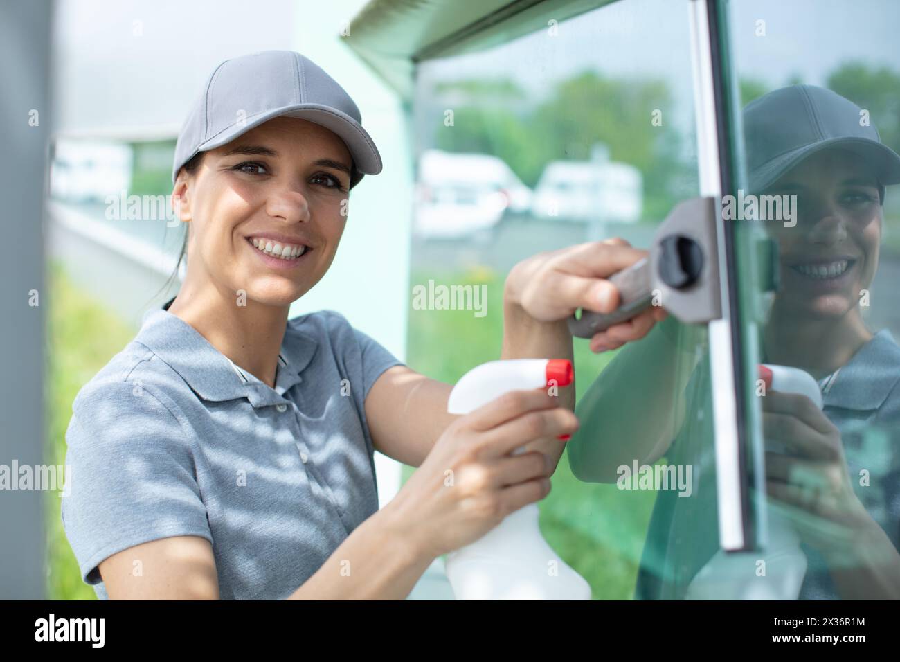 woman cleaning a window with cleaning sprayer Stock Photo - Alamy