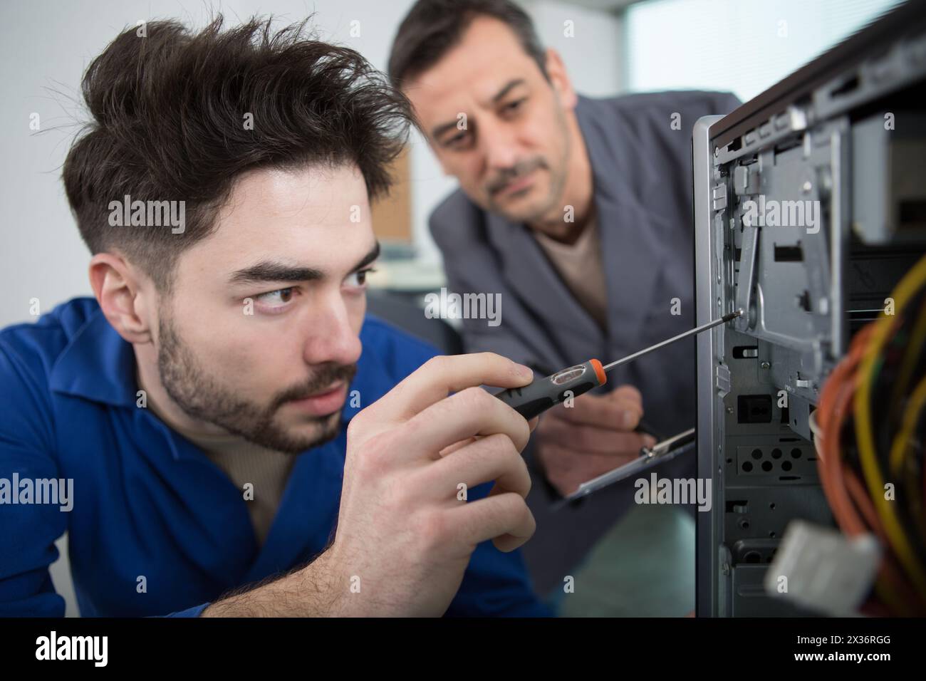 apprentice learning to fix a pc Stock Photo - Alamy