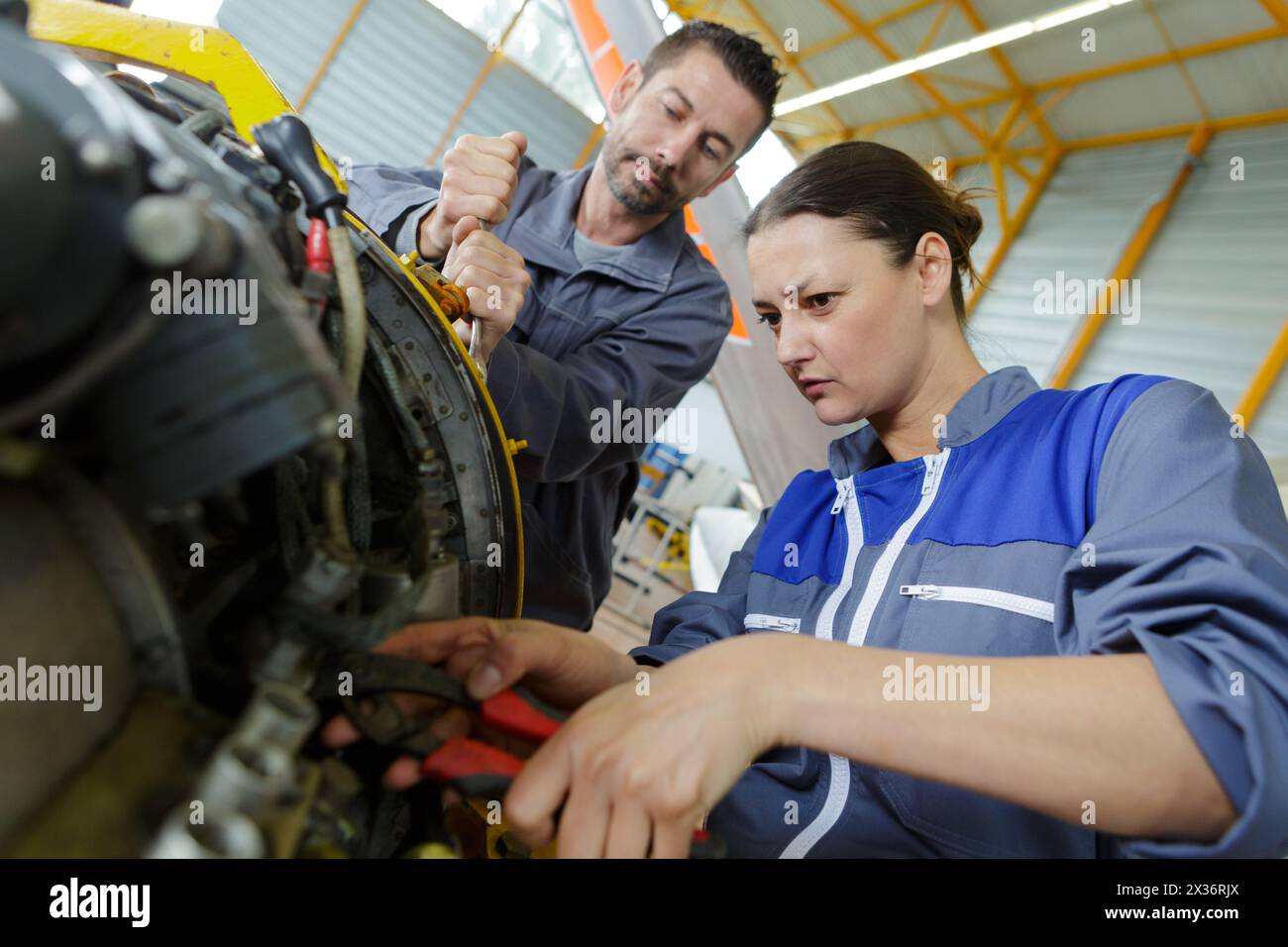 female and male mechanic fixing a compressor engine Stock Photo - Alamy