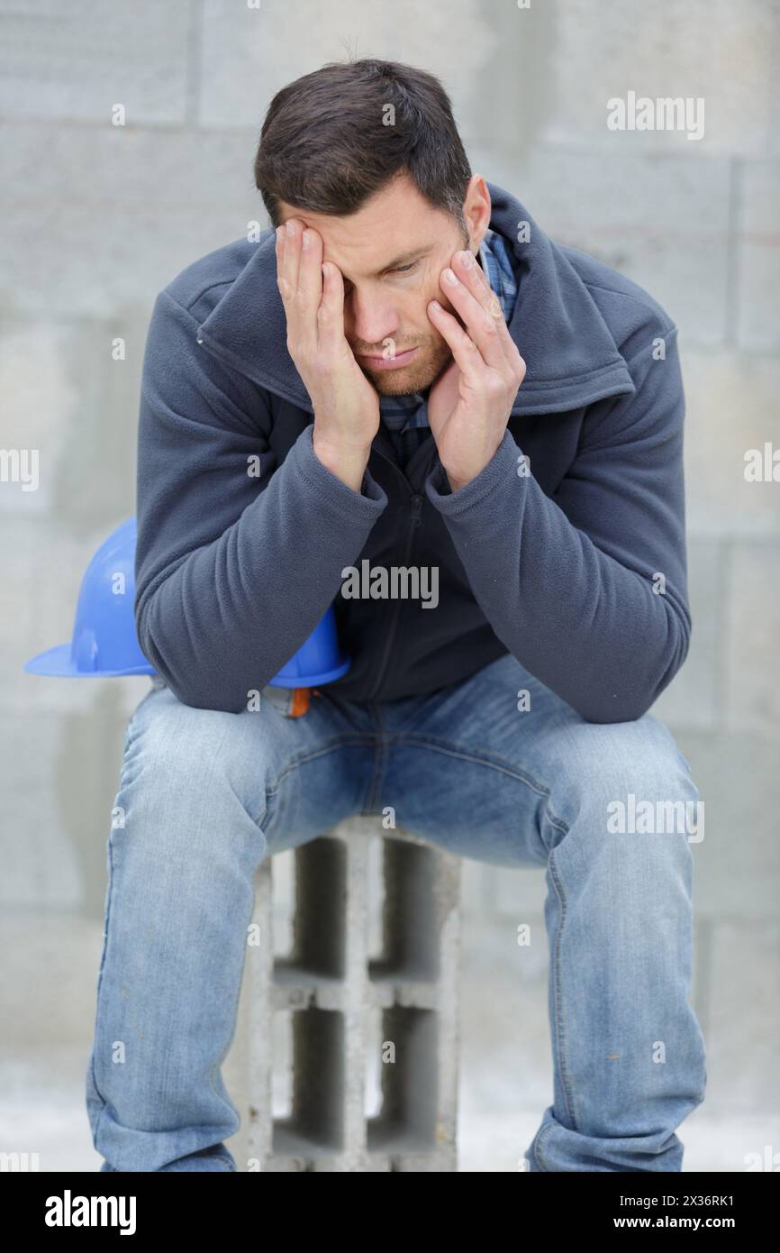 tired builder holds his face Stock Photo - Alamy