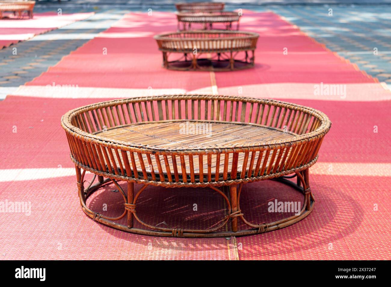 A row of empty baskets on a mat in an outdoor restaurant - Khan Toke ...
