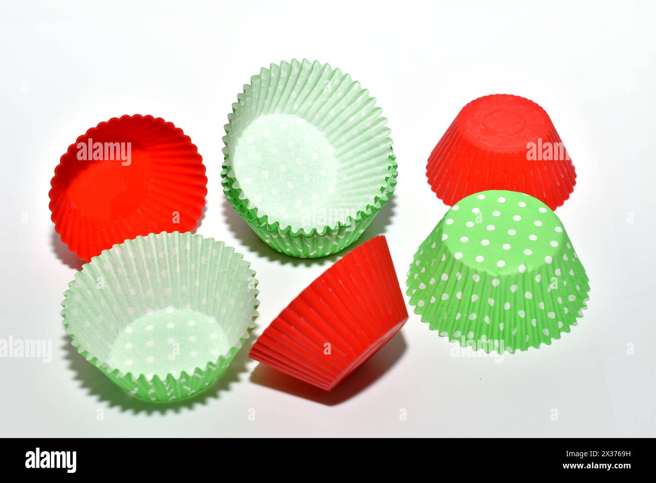 Molds made from paper for baking cupcakes lie chaotically on a white ...