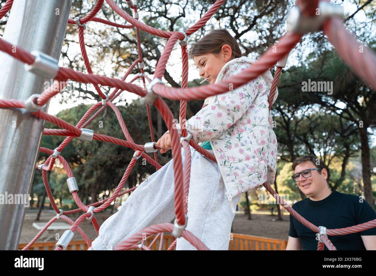 A joyful interaction between a child and an adult at a park, as the ...