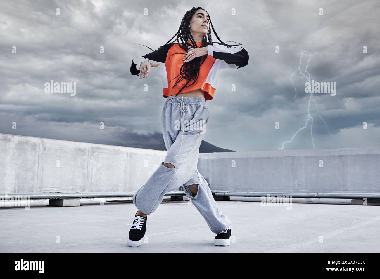 Woman, dance and hip hop outdoor on city rooftop with lightning storm ...
