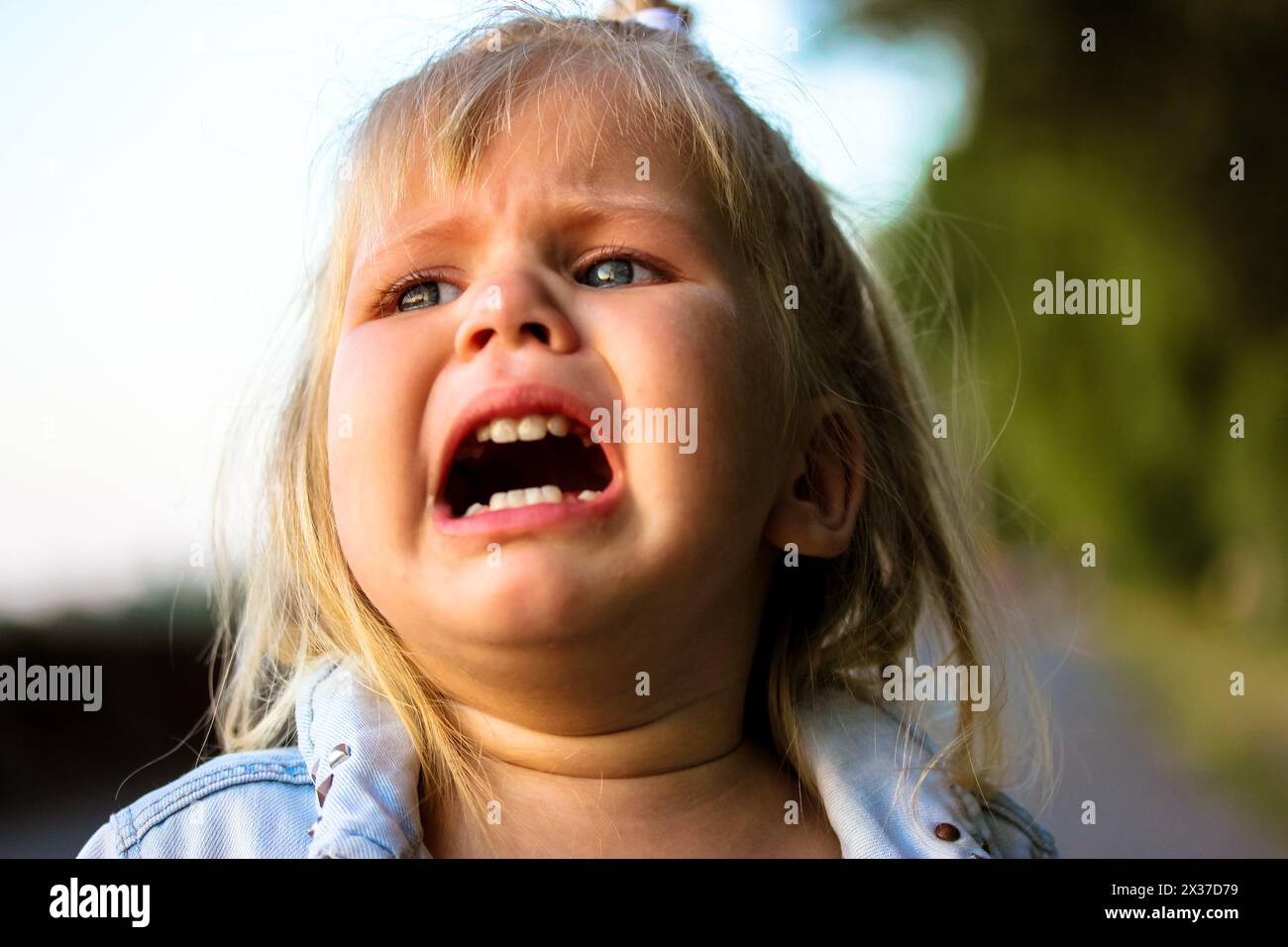 Unhappy child crying loudly with mouth open because of parents' divorce ...