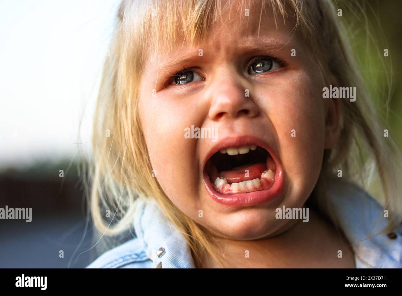 Unhappy child crying loudly with mouth open because of parents' divorce ...