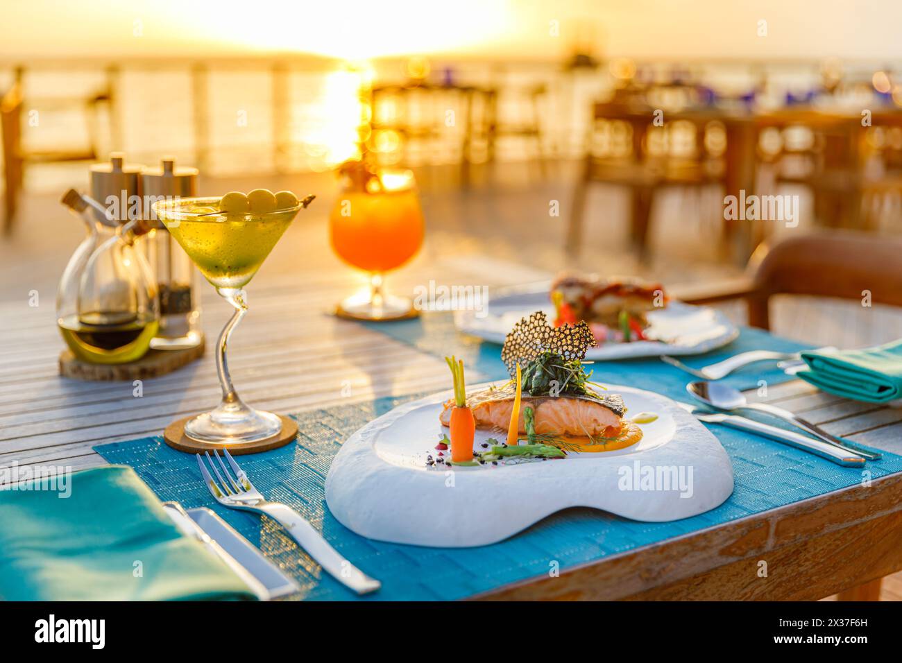 Romantic sunset dinner on beach. Table honeymoon set two luxurious food ...