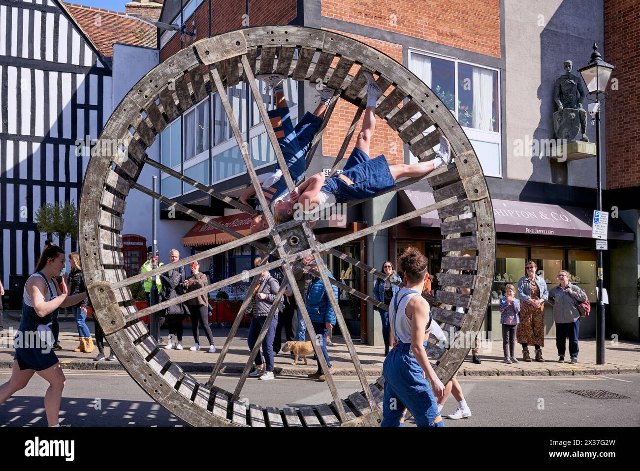 Shakespeare celebration parade with acrobats rolling a large wooden ...