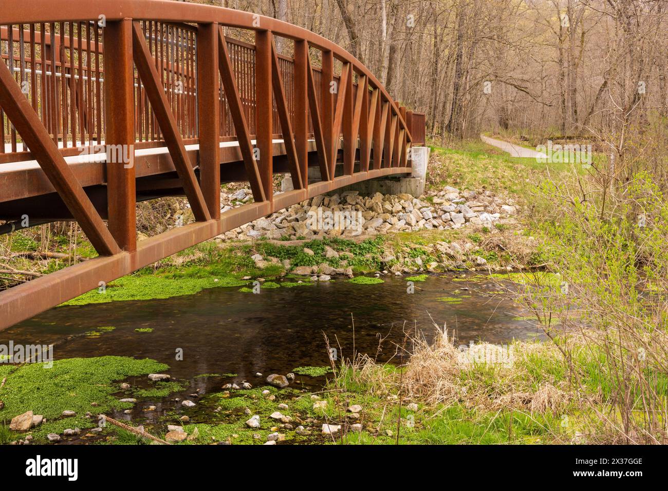 A footbridge on a hiking trail crossing a creek in the woods during ...