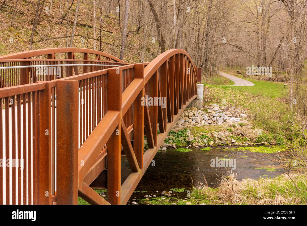 A footbridge on a hiking trail crossing a creek in the woods during ...