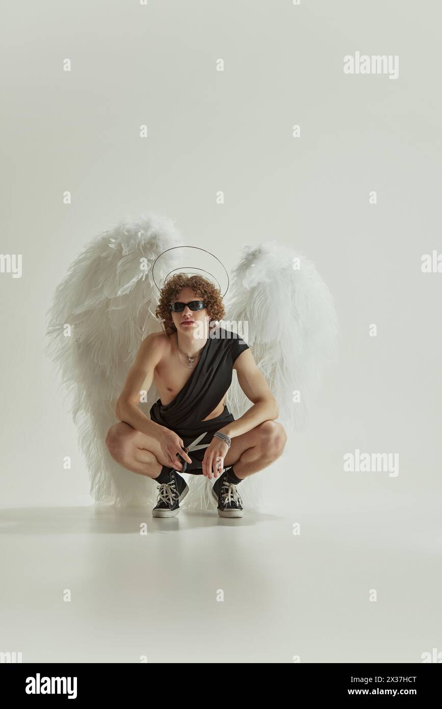Man looks as angel, mythology character sitting in modern sunglasses ...