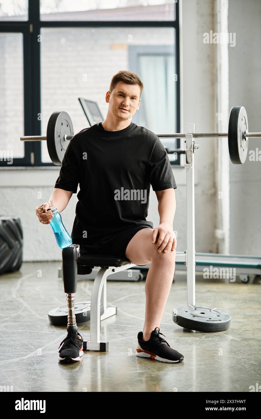 A determined man with a prosthetic leg sits in a chair, near a barbell ...