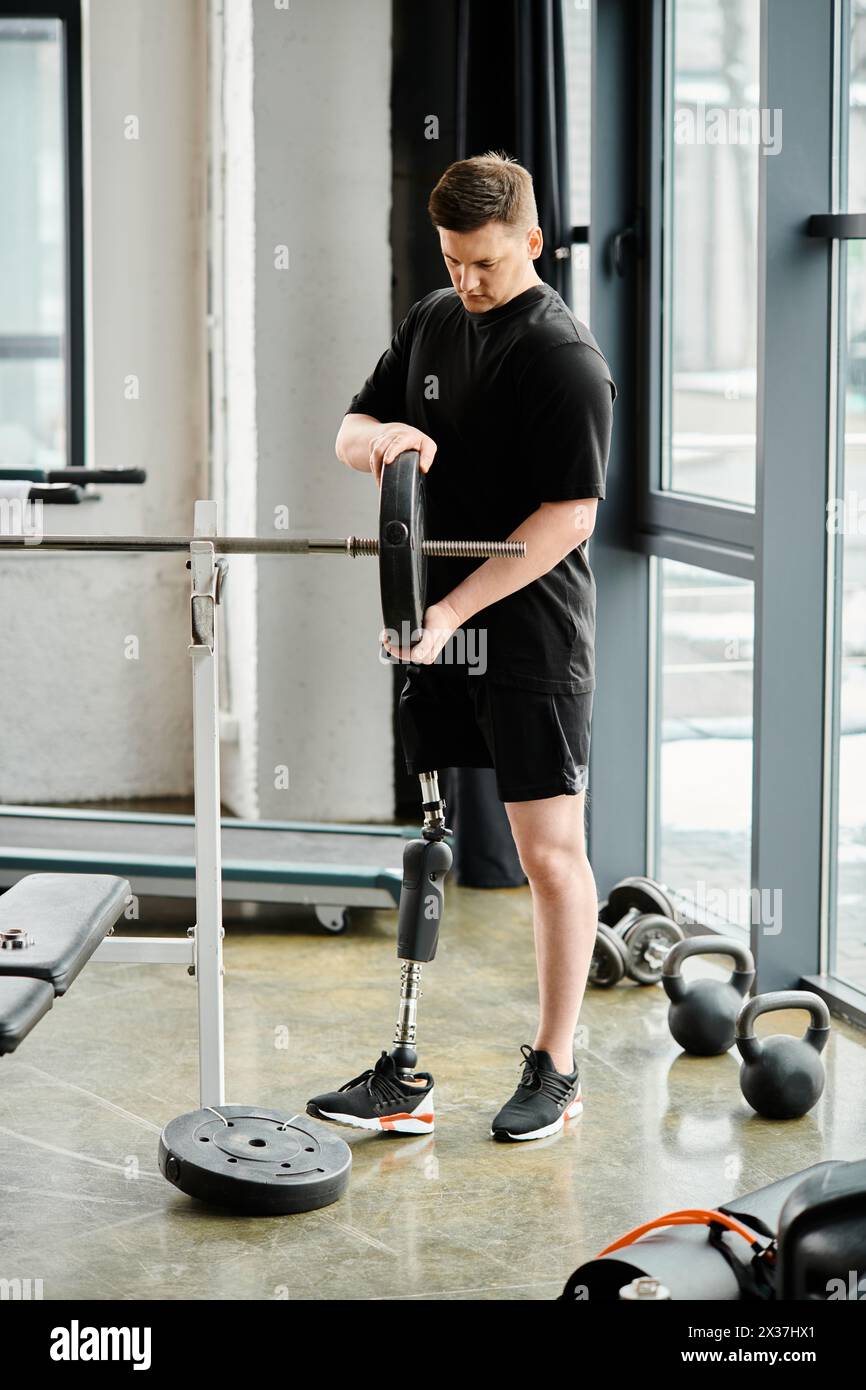A disabled man with a prosthetic leg working out on a machine in a gym ...