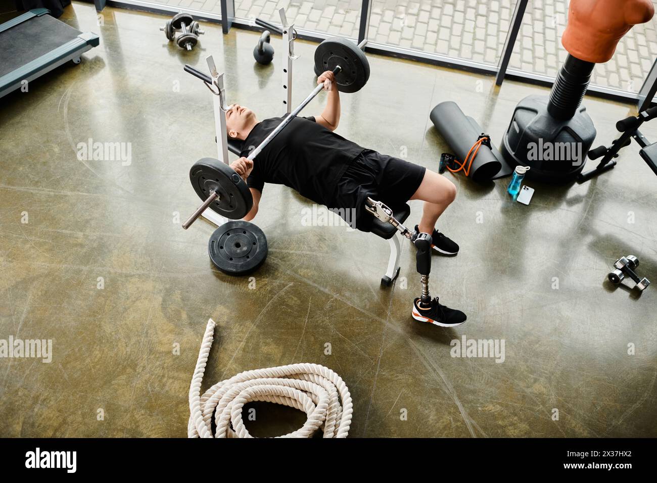 A determined man with a prosthetic leg performs a bench press using a ...
