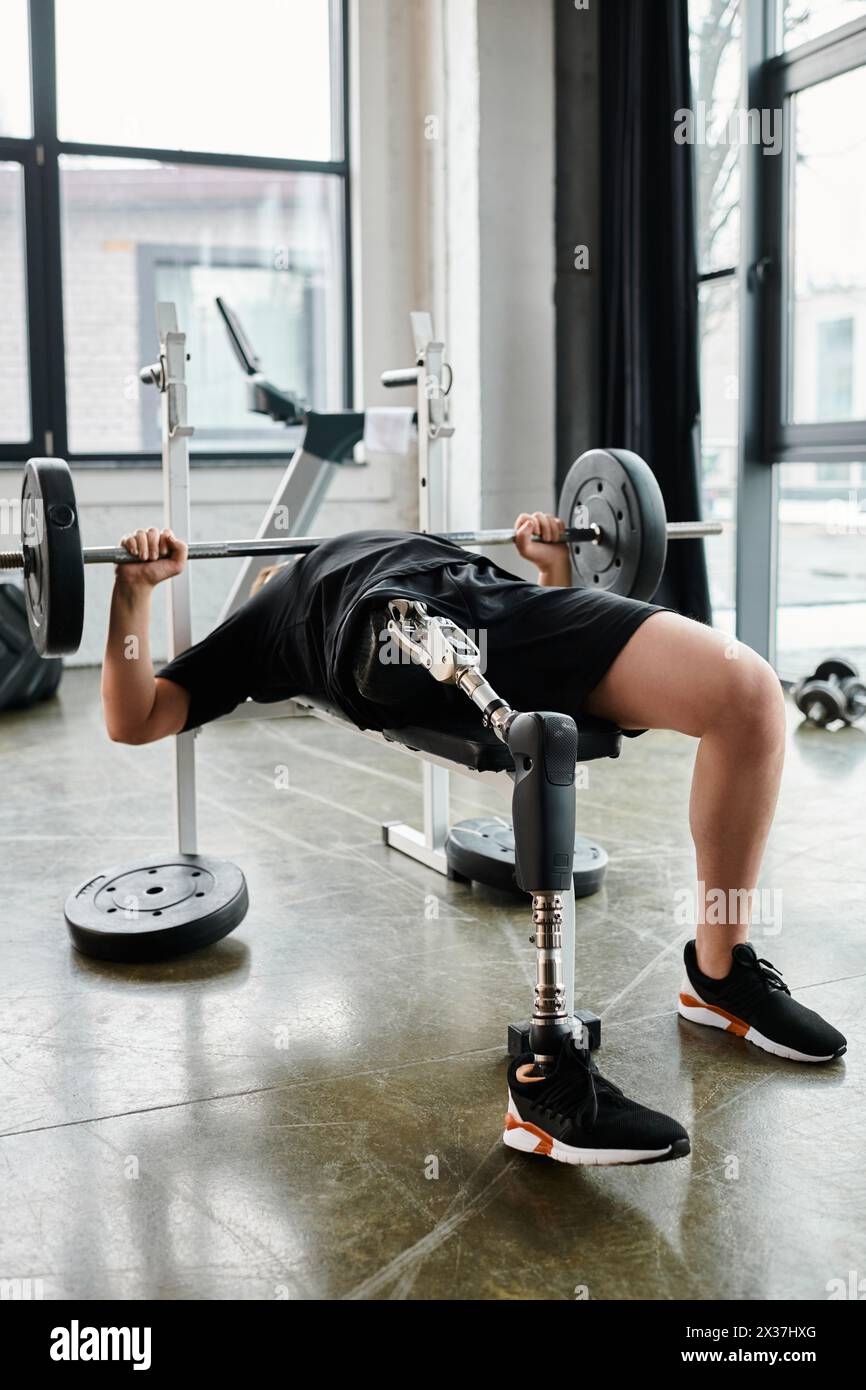 A man, with a prosthetic leg, lifting a barbell while doing a bench ...