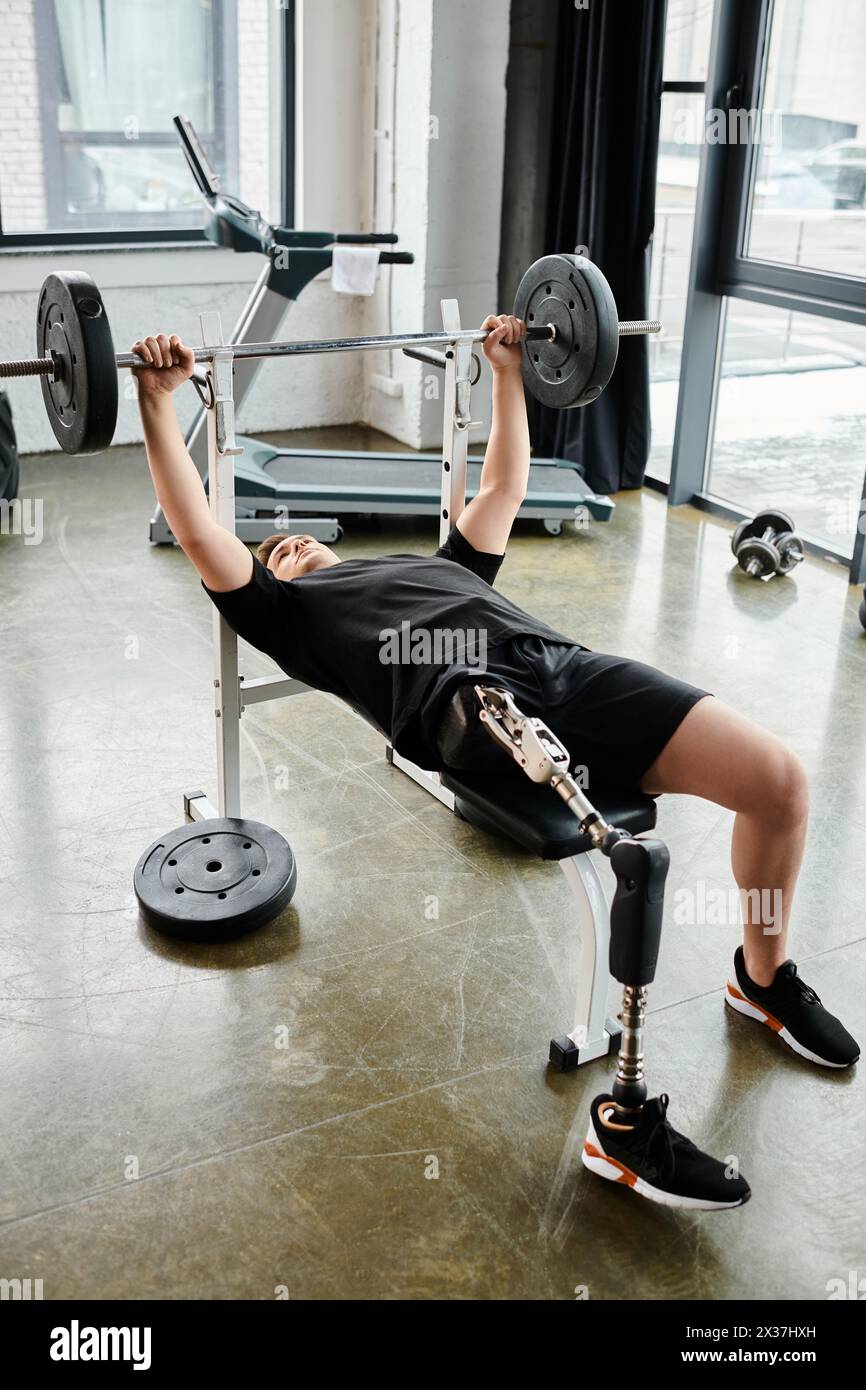 A man, with a prosthetic leg, is performing a bench press exercise with ...