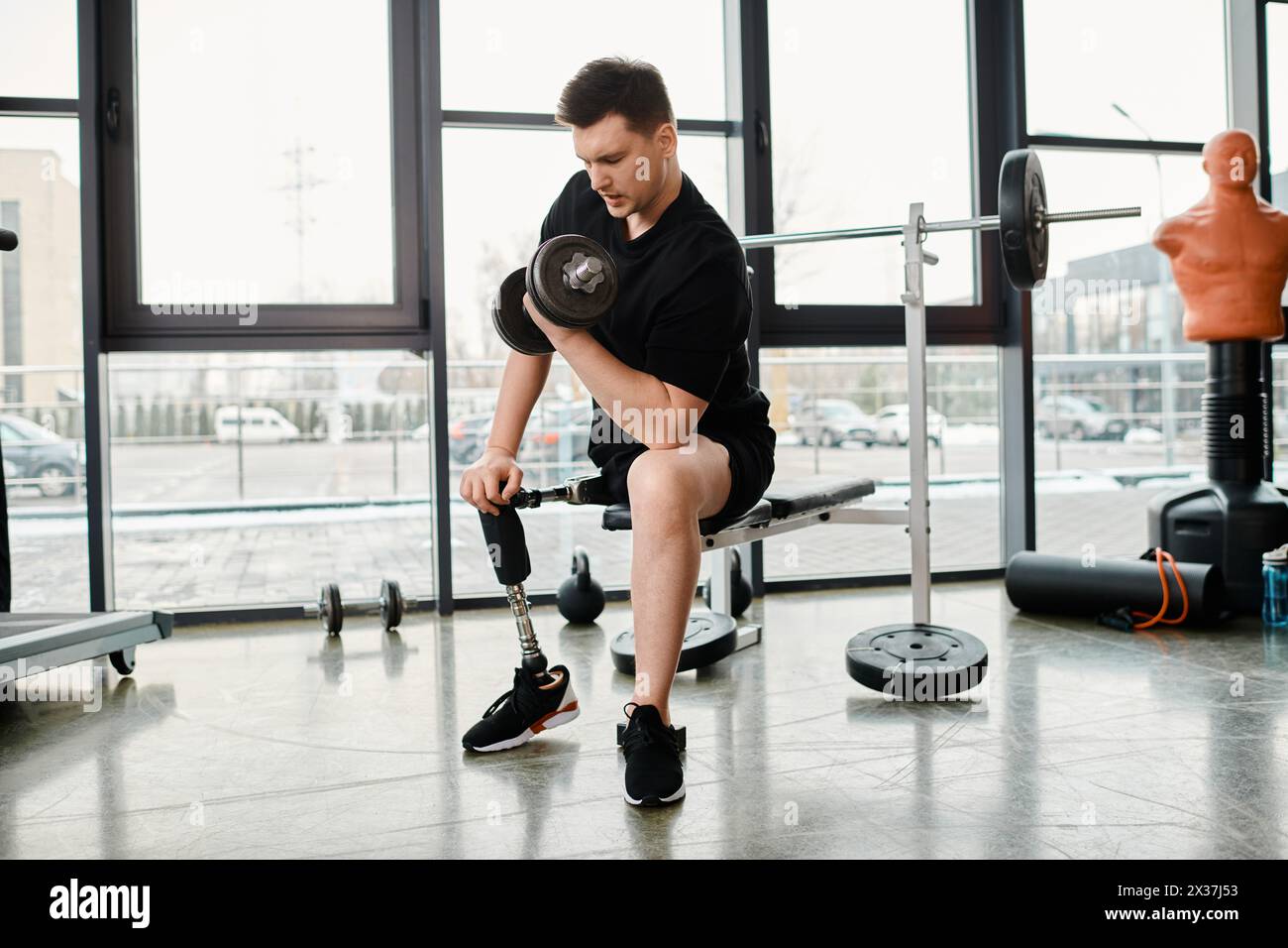A determined man with a prosthetic leg performing a squat exercise with ...
