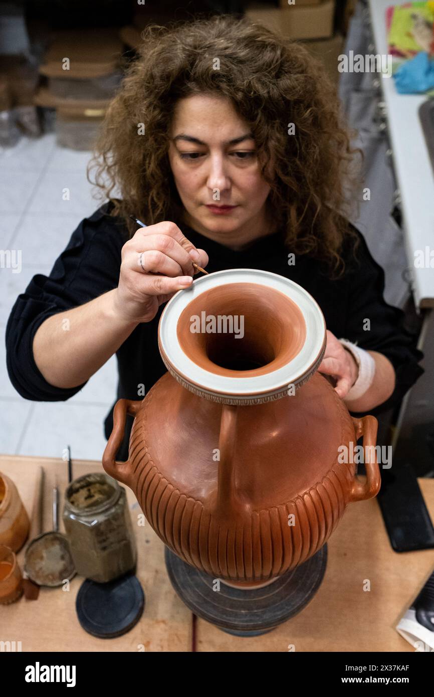 Woman painting a vase inspired by ancient Greek amphorae in the ...