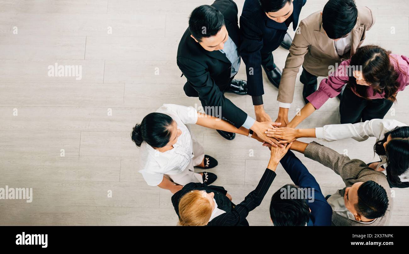 Aerial perspective of four diverse professionals in a circle hands ...